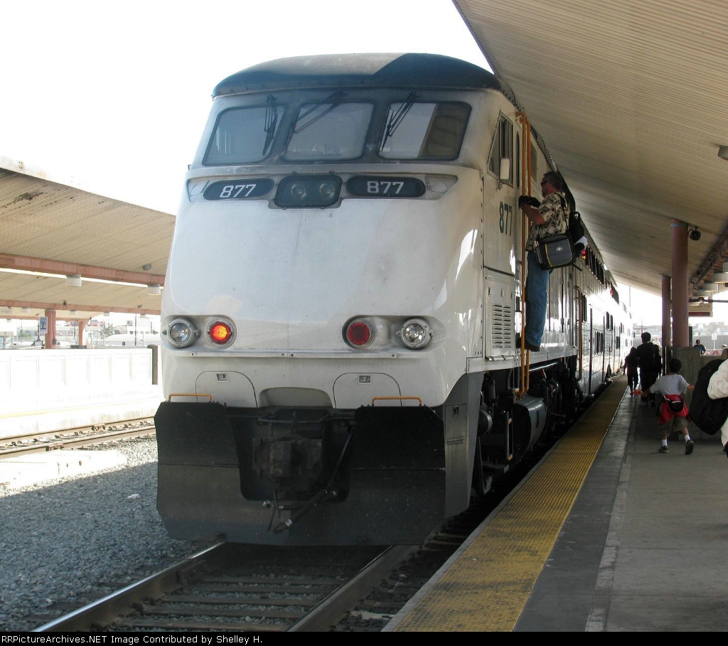 A Metrolink Engineer opening the cab door of 877